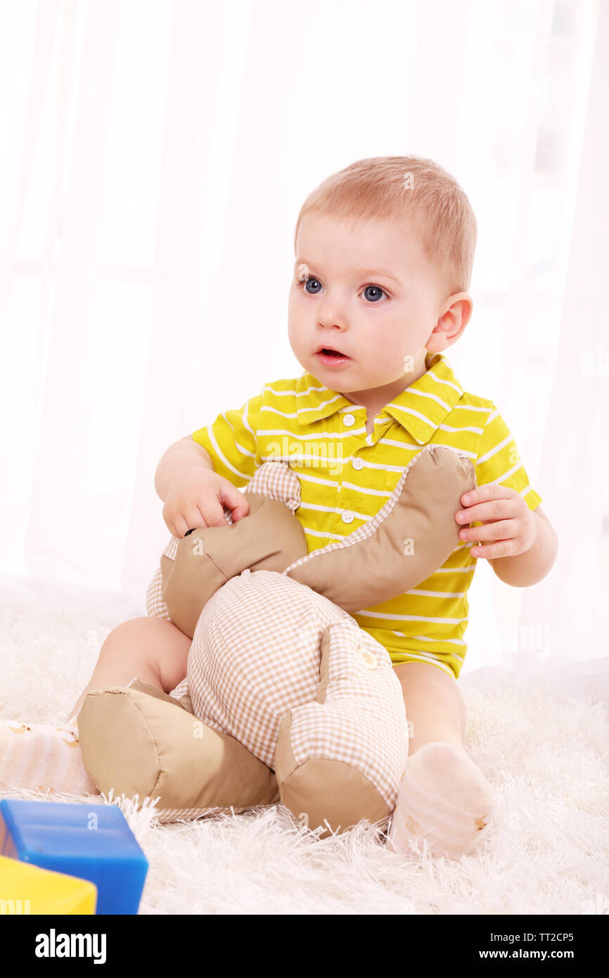 Cute little boy with teddy bear in room Stock Photo - Alamy