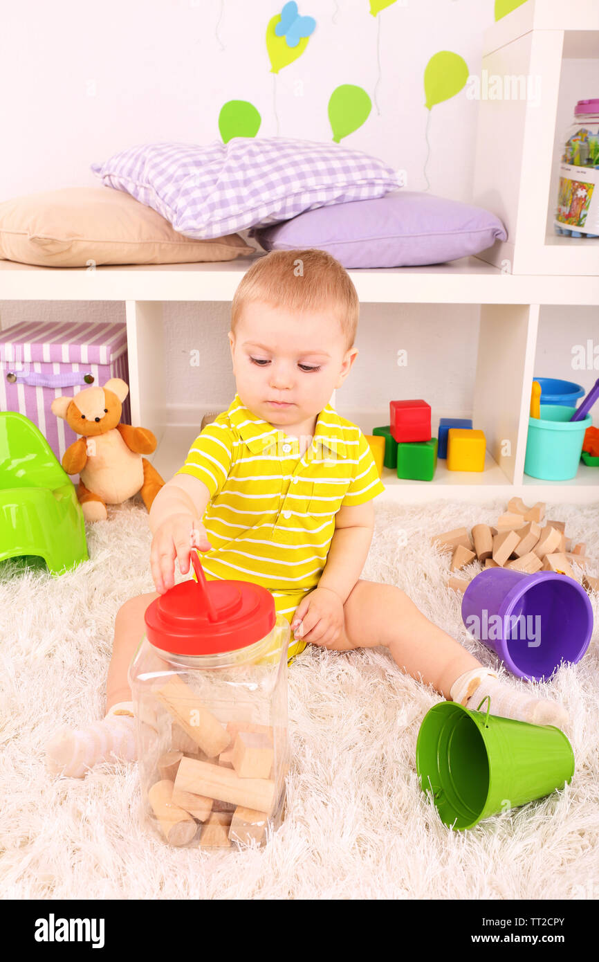 Cute little boy with wooden toy blocks in room Stock Photo - Alamy