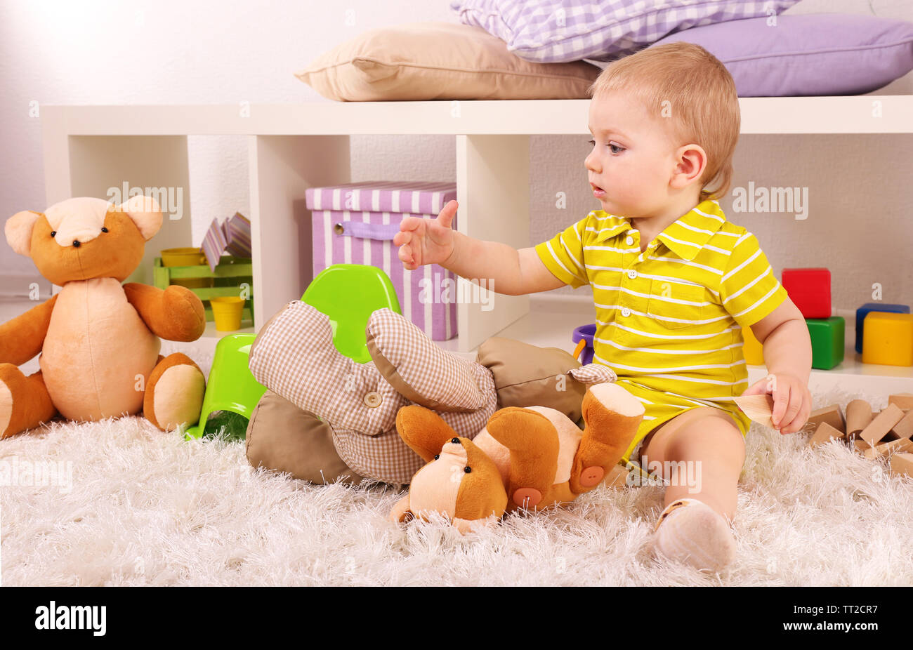 Cute little boy with toys in room Stock Photo - Alamy