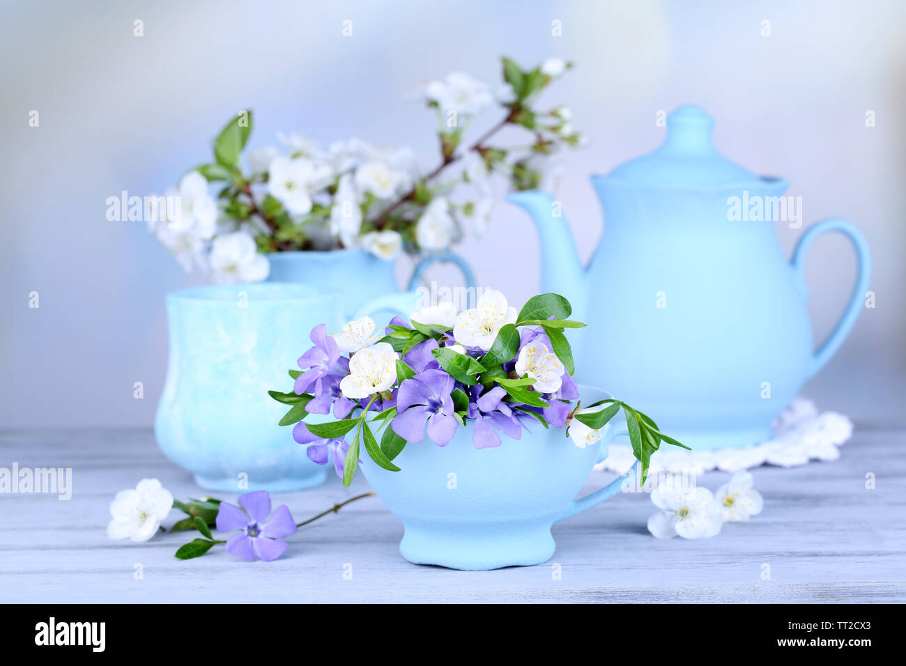 Beautiful spring flowers in cups on wooden table Stock Photo - Alamy