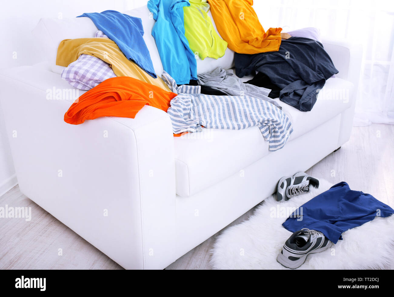 Messy colorful male clothing on sofa on light background Stock Photo ...