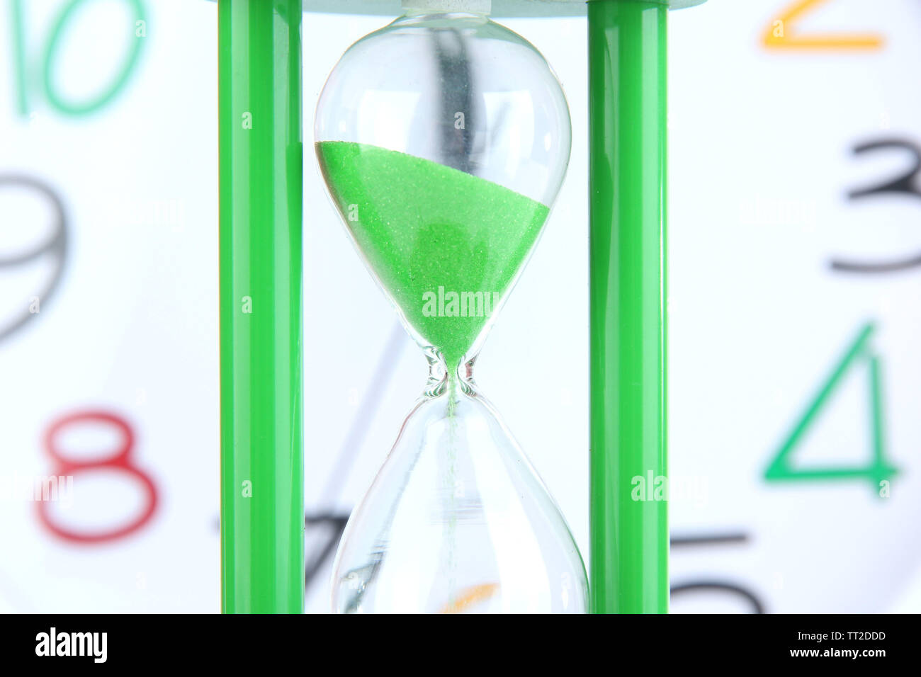 Hourglass on big clock background Stock Photo - Alamy