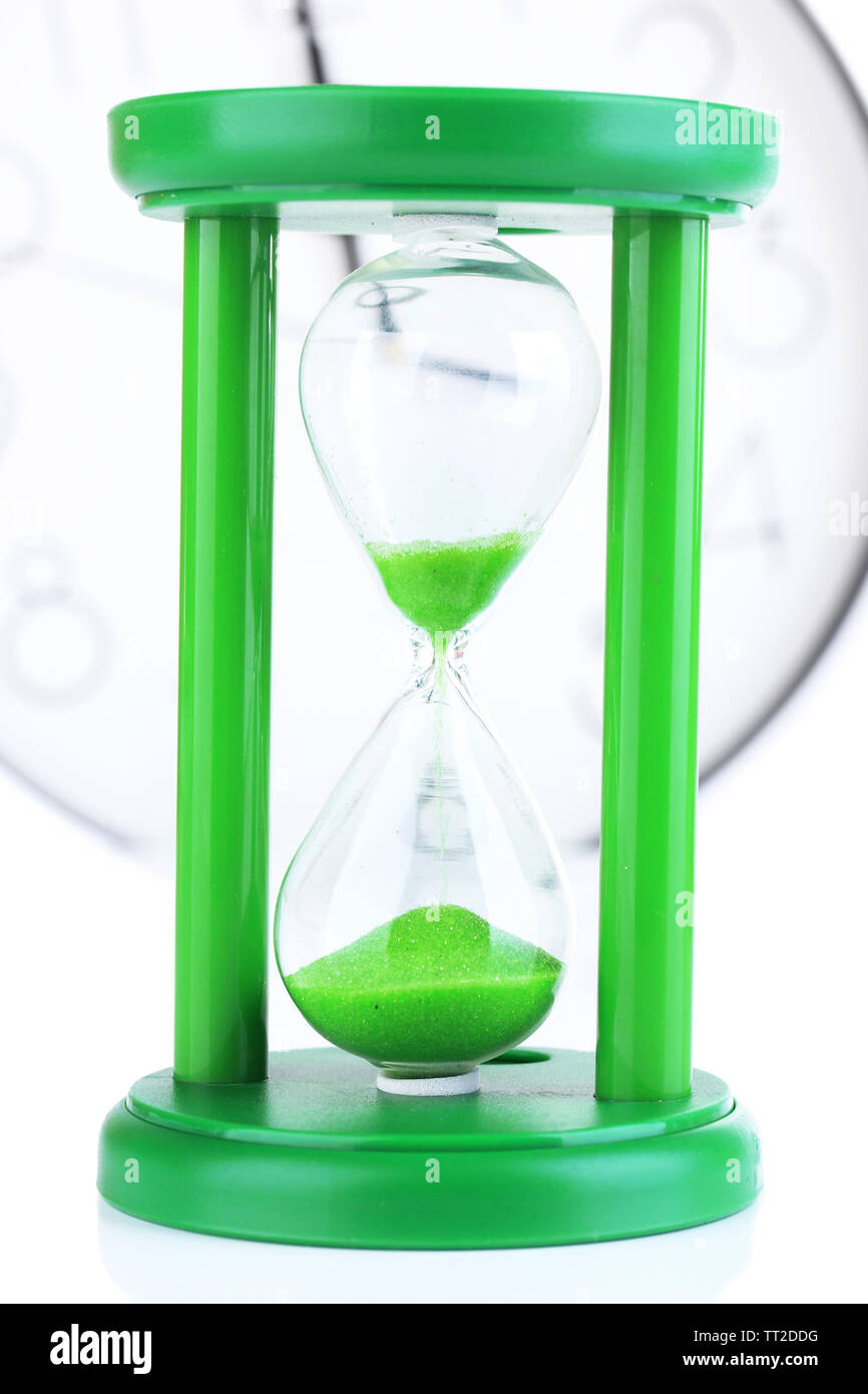 Hourglass on big clock background Stock Photo - Alamy
