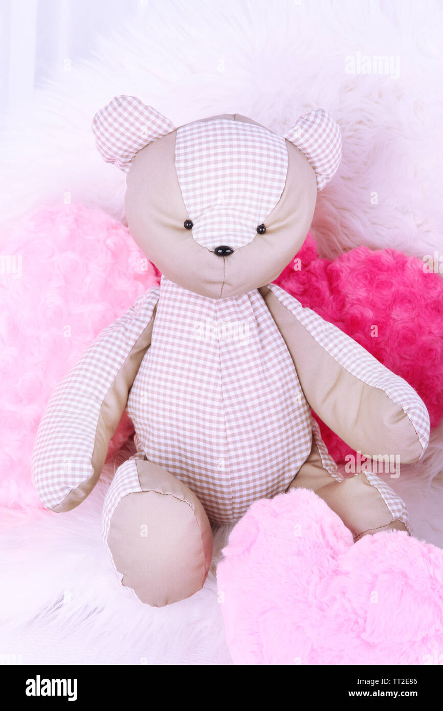 Bear toy with pillows on armchair in room Stock Photo - Alamy