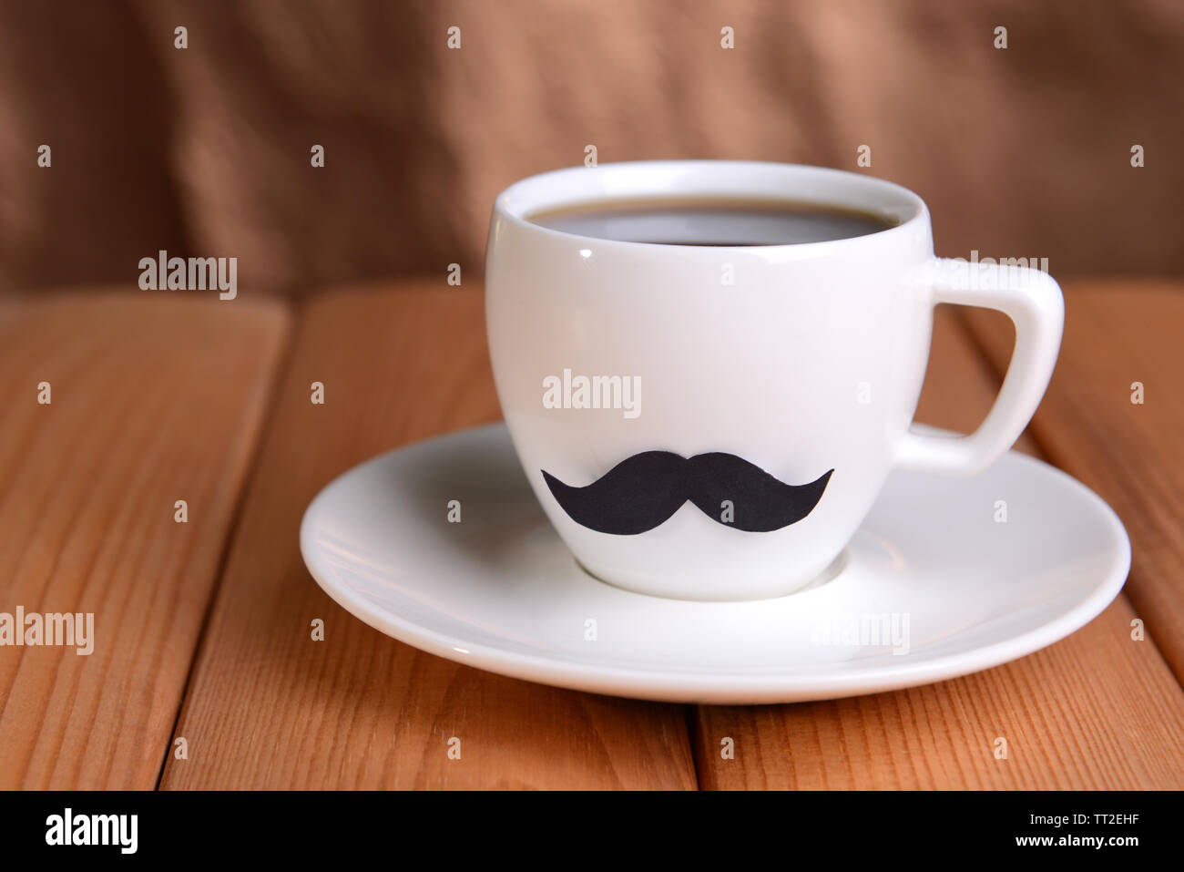 Cup with mustache on table on brown background Stock Photo - Alamy