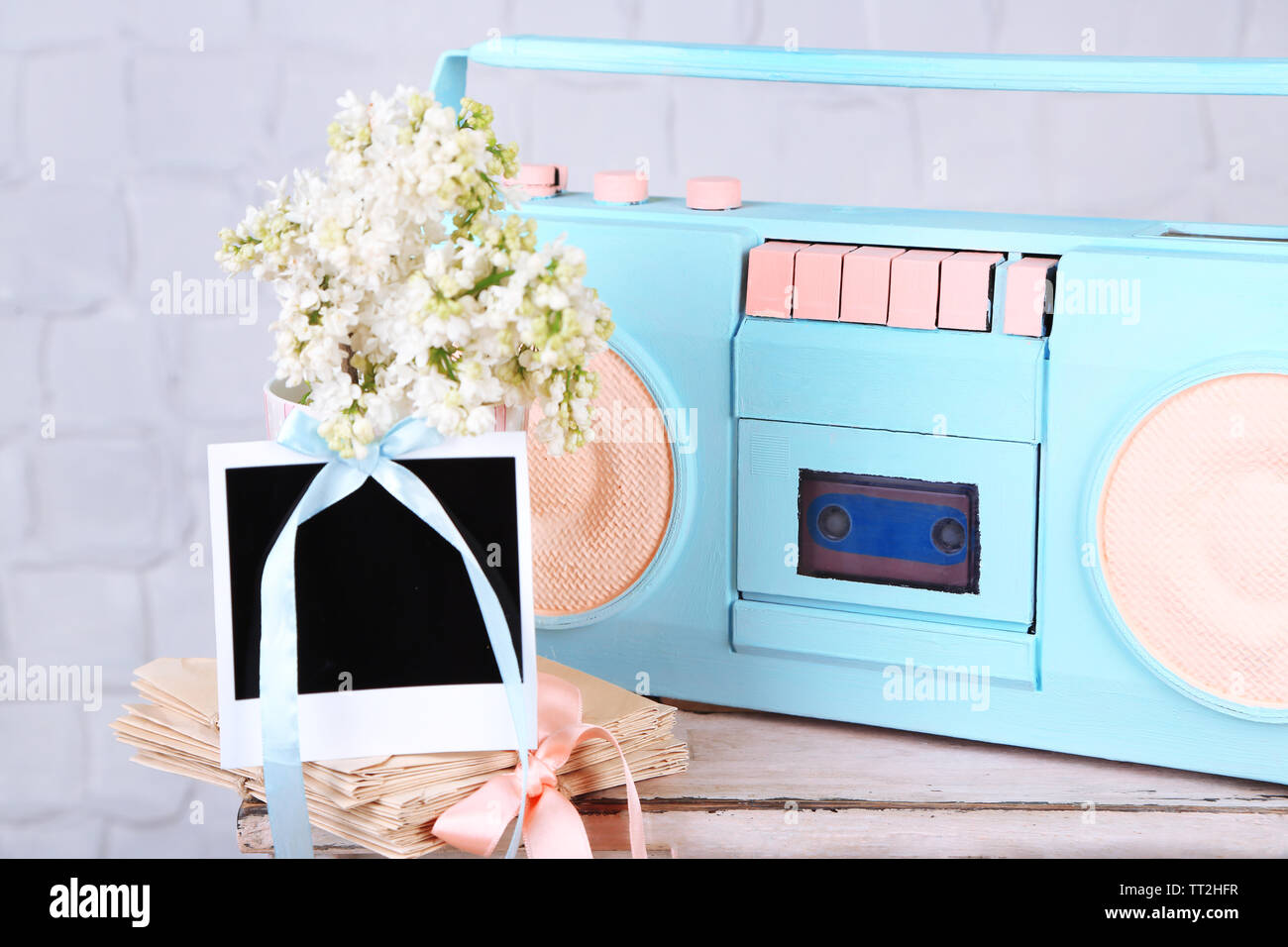 Still life with colorful retro radio, on grey wall wooden background ...