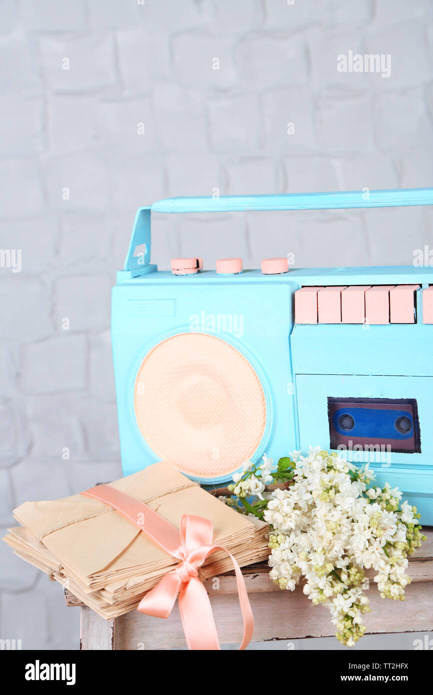 Still life with colorful retro radio, on grey wall wooden background ...