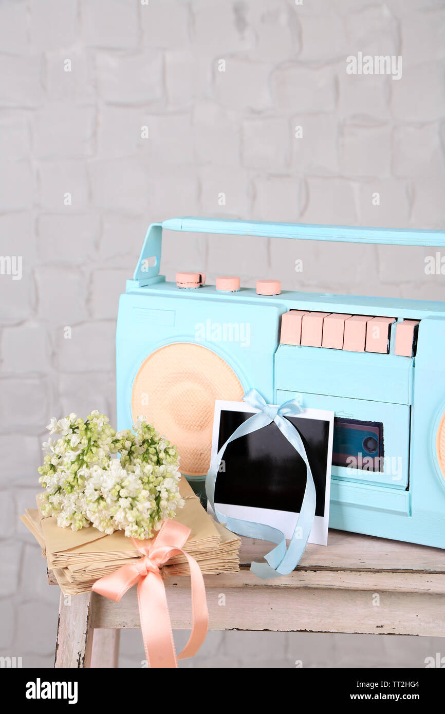 Still life with colorful retro radio, on grey wall wooden background ...
