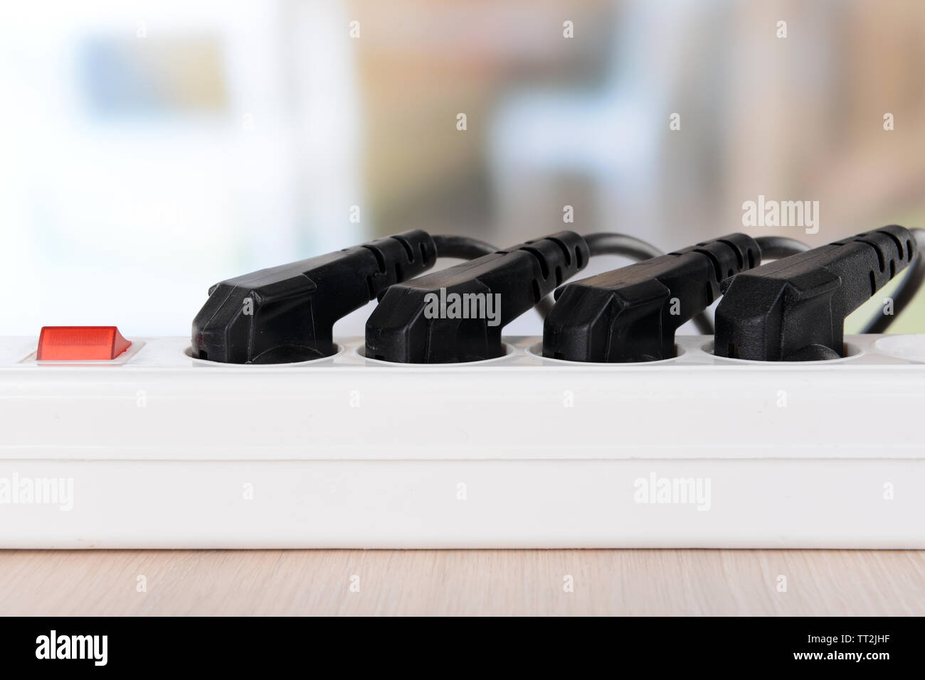 Many plugs plugged into electric power bar close-up Stock Photo - Alamy