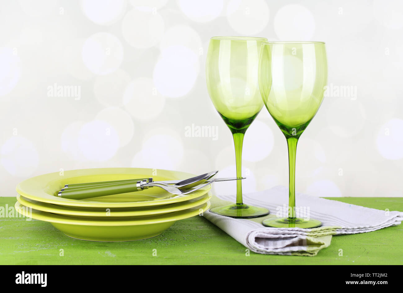 Green table settings, on table, on light background Stock Photo - Alamy