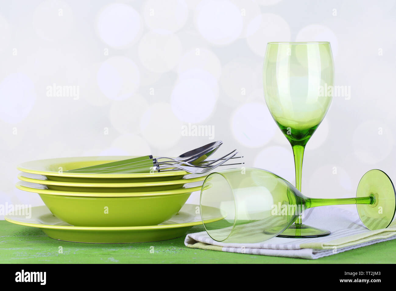 Green table settings, on table, on light background Stock Photo - Alamy