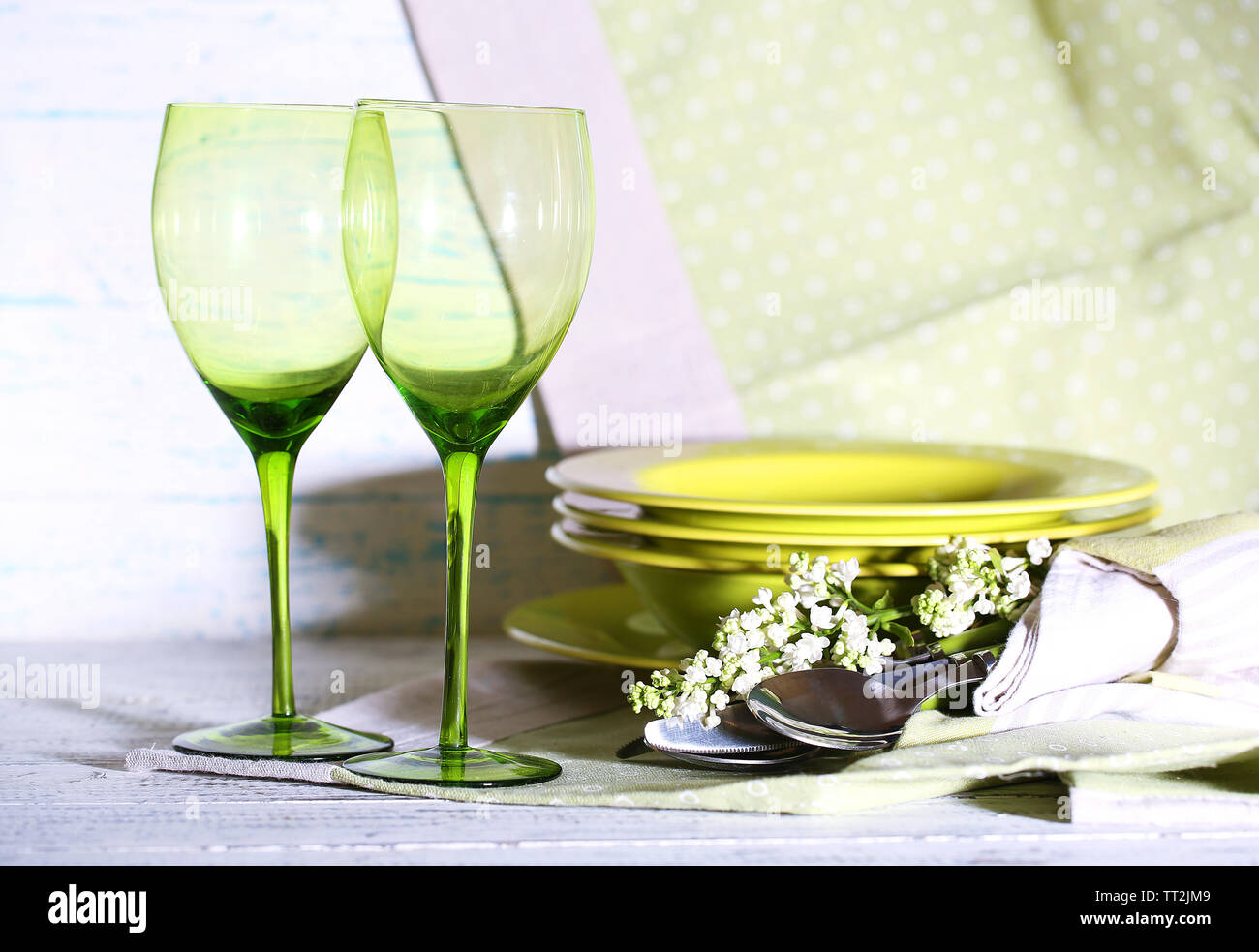 Green table settings, on table, on light background Stock Photo - Alamy