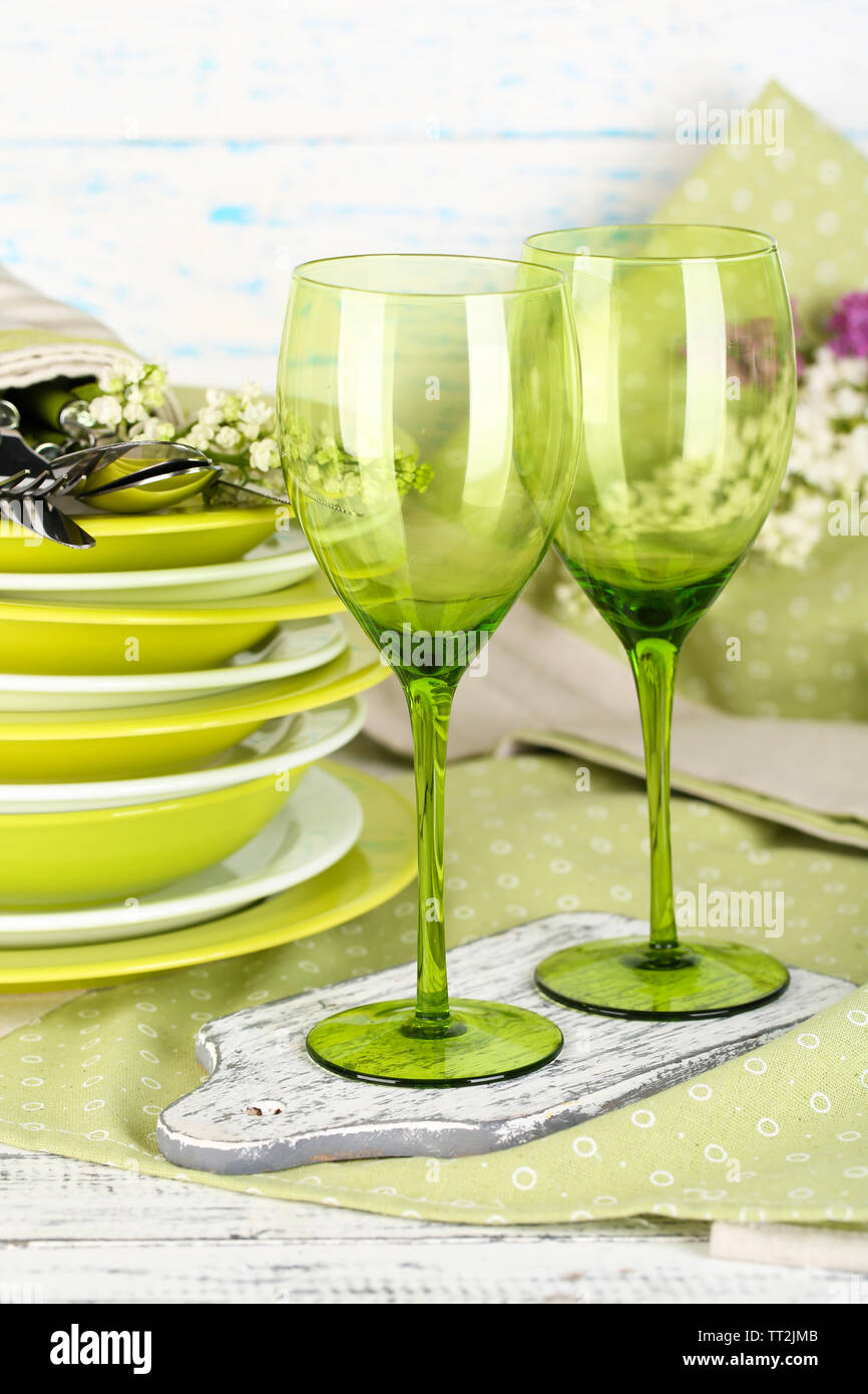 Green table settings, on table, on light background Stock Photo - Alamy