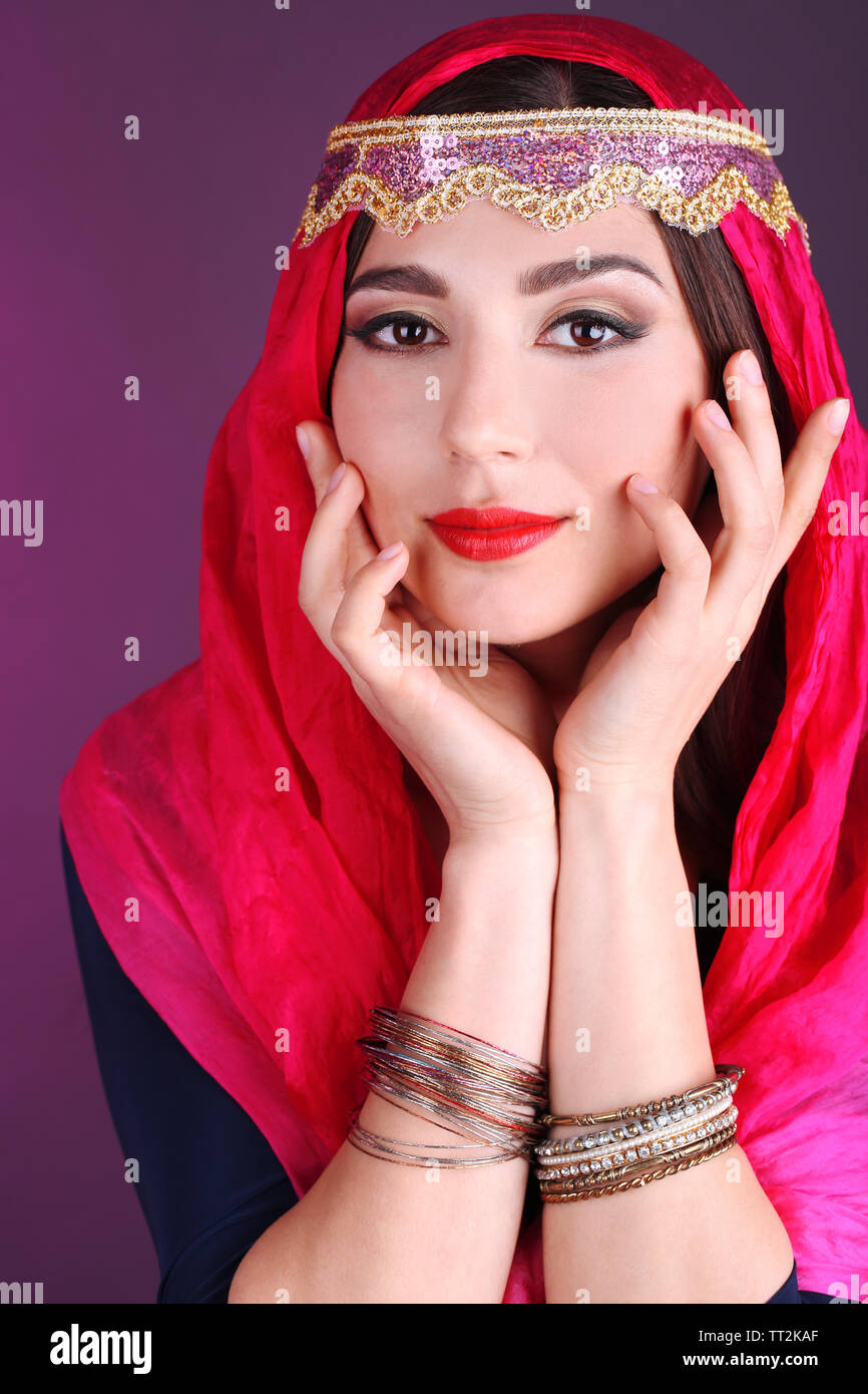 Beautiful oriental girl on dark colorful background Stock Photo - Alamy