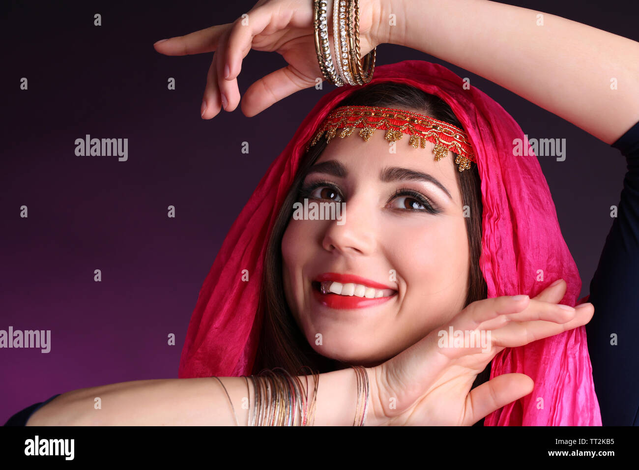 Beautiful oriental girl on dark colorful background Stock Photo - Alamy