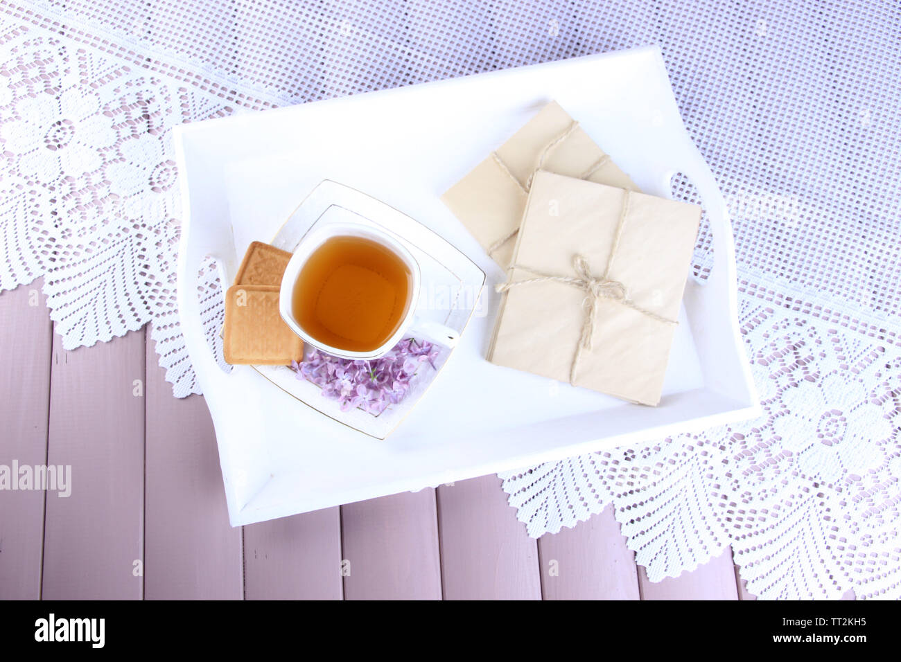 Composition with cup of tea, old letters on tray, on color wooden ...