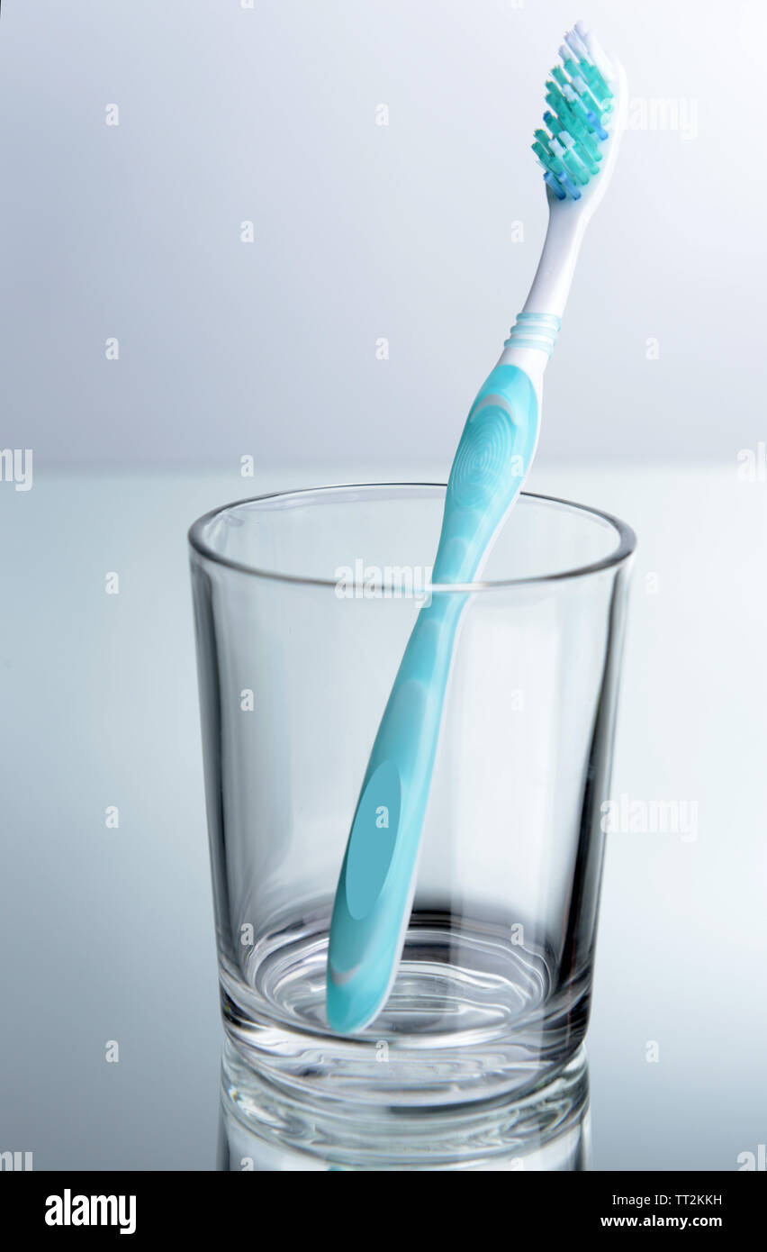 Toothbrush in glass on light grey background Stock Photo - Alamy