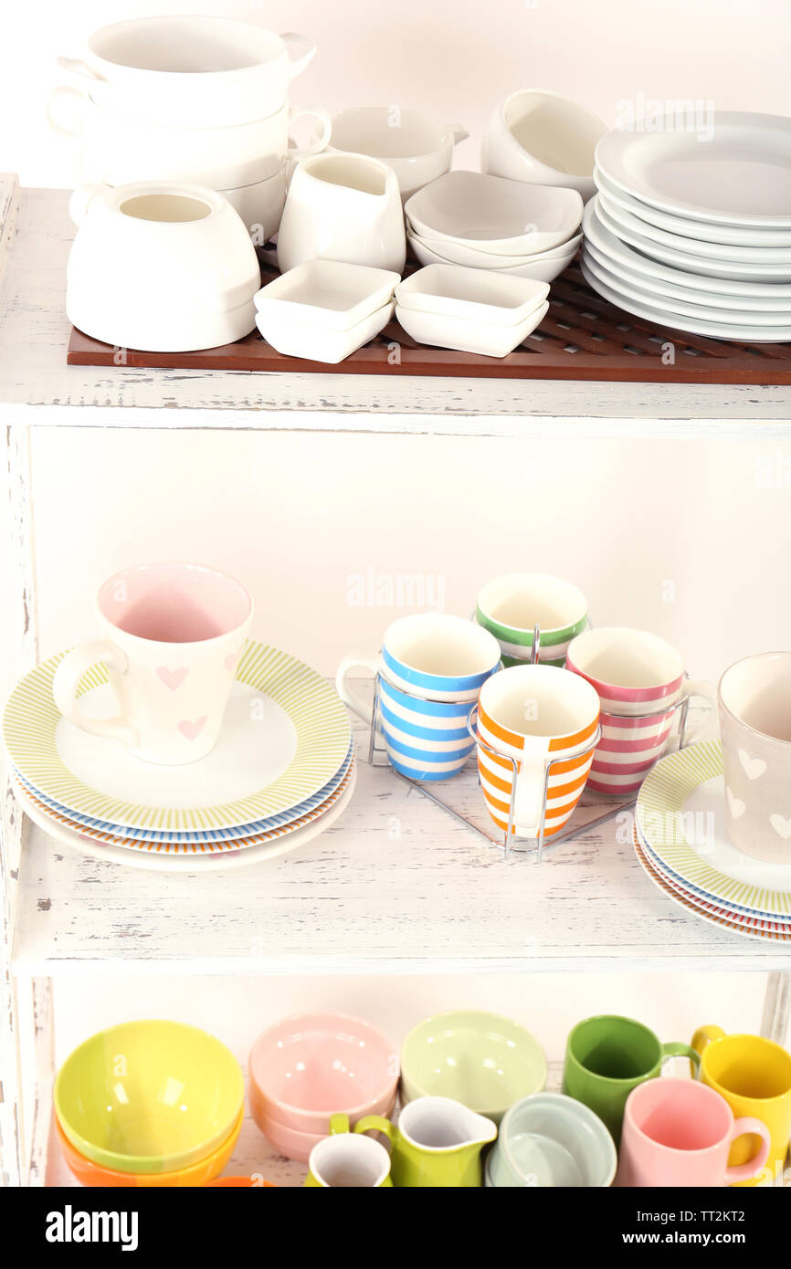 Different tableware on shelves, isolated on white Stock Photo - Alamy