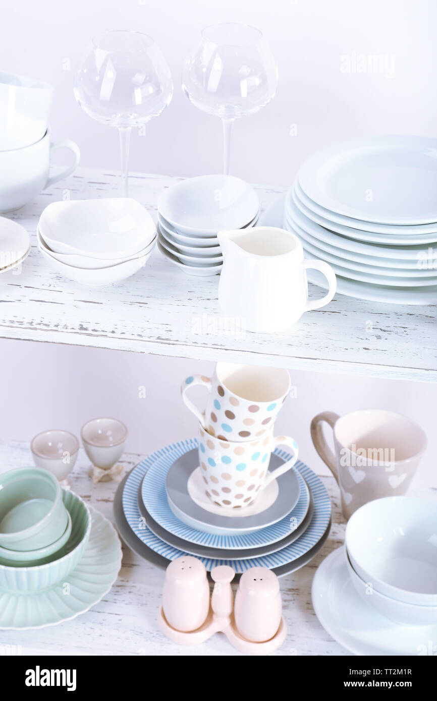 Different tableware on shelf, isolated on white Stock Photo - Alamy