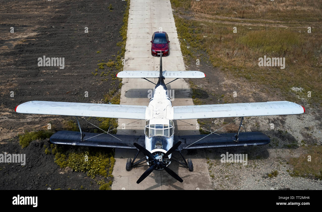 sports red car next to the plane Stock Photo - Alamy