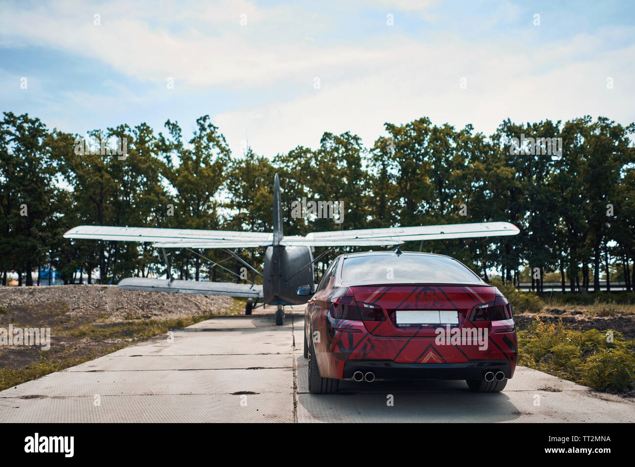 sports red car next to the plane Stock Photo - Alamy