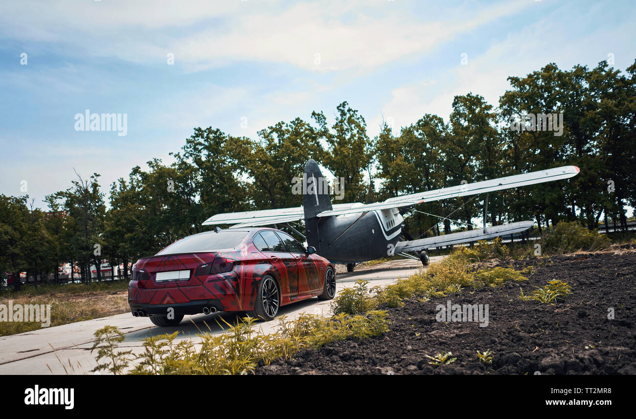 sports red car next to the plane Stock Photo - Alamy