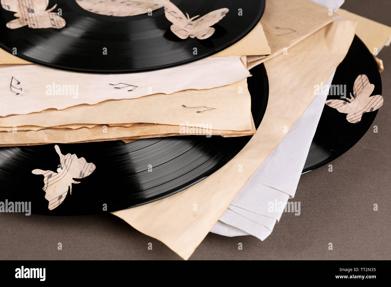 Old vinyl records with old paper and butterflies, on brown background ...