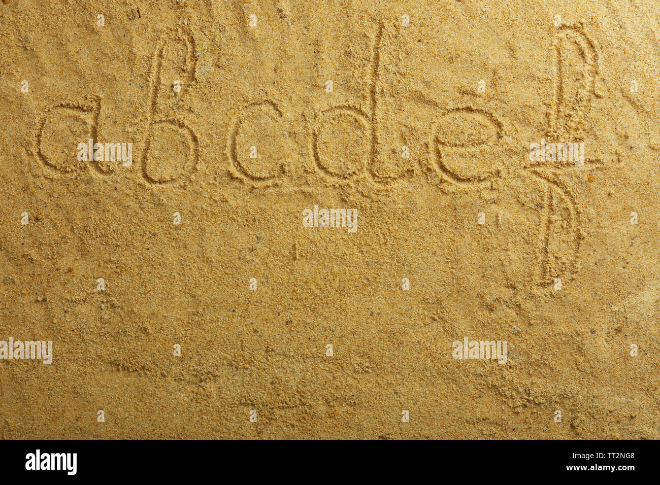 Alphabet letters written on wet beach sand Stock Photo - Alamy