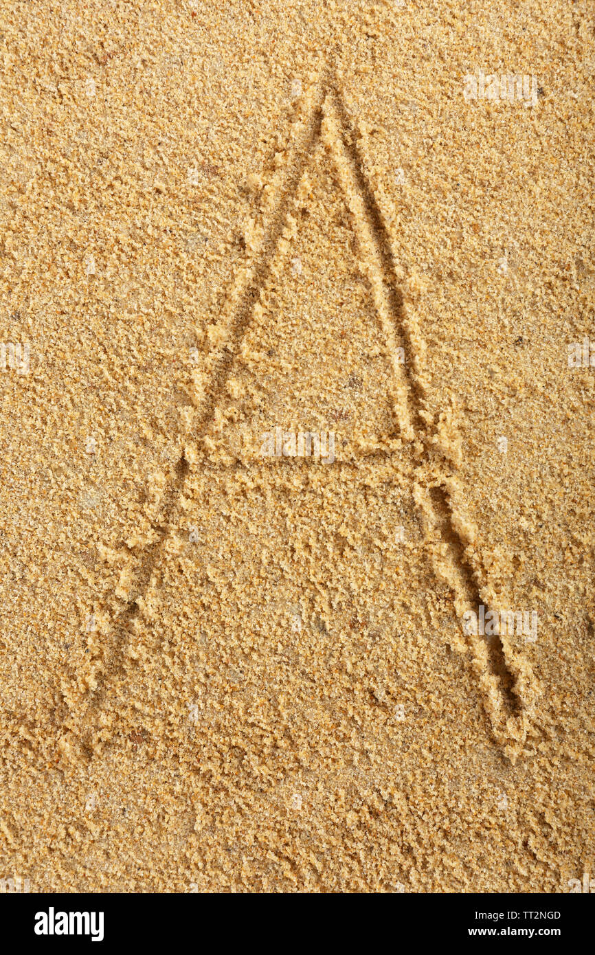 Alphabet letter written on wet beach sand Stock Photo - Alamy