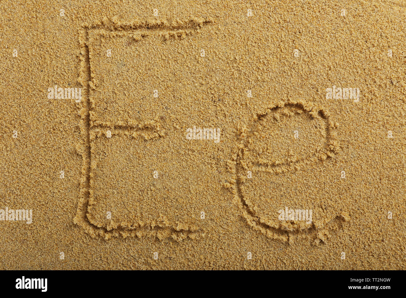 Alphabet letter written on wet beach sand Stock Photo - Alamy