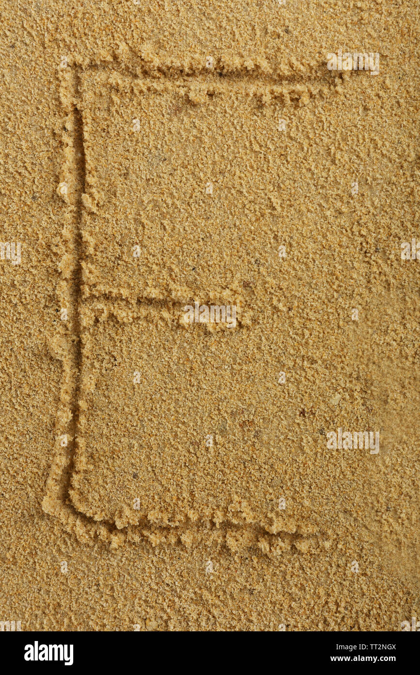 Alphabet letter written on wet beach sand Stock Photo - Alamy