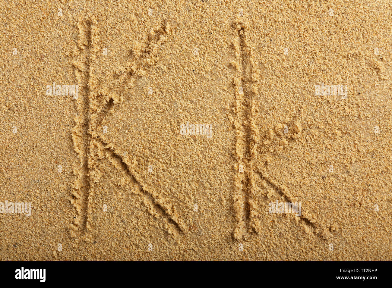 Alphabet letter written on wet beach sand Stock Photo - Alamy