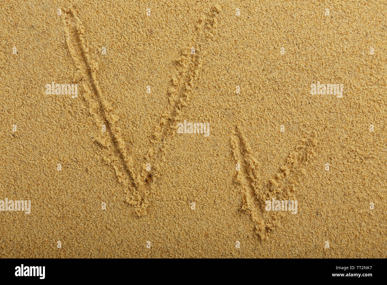 Alphabet letter written on wet beach sand Stock Photo - Alamy