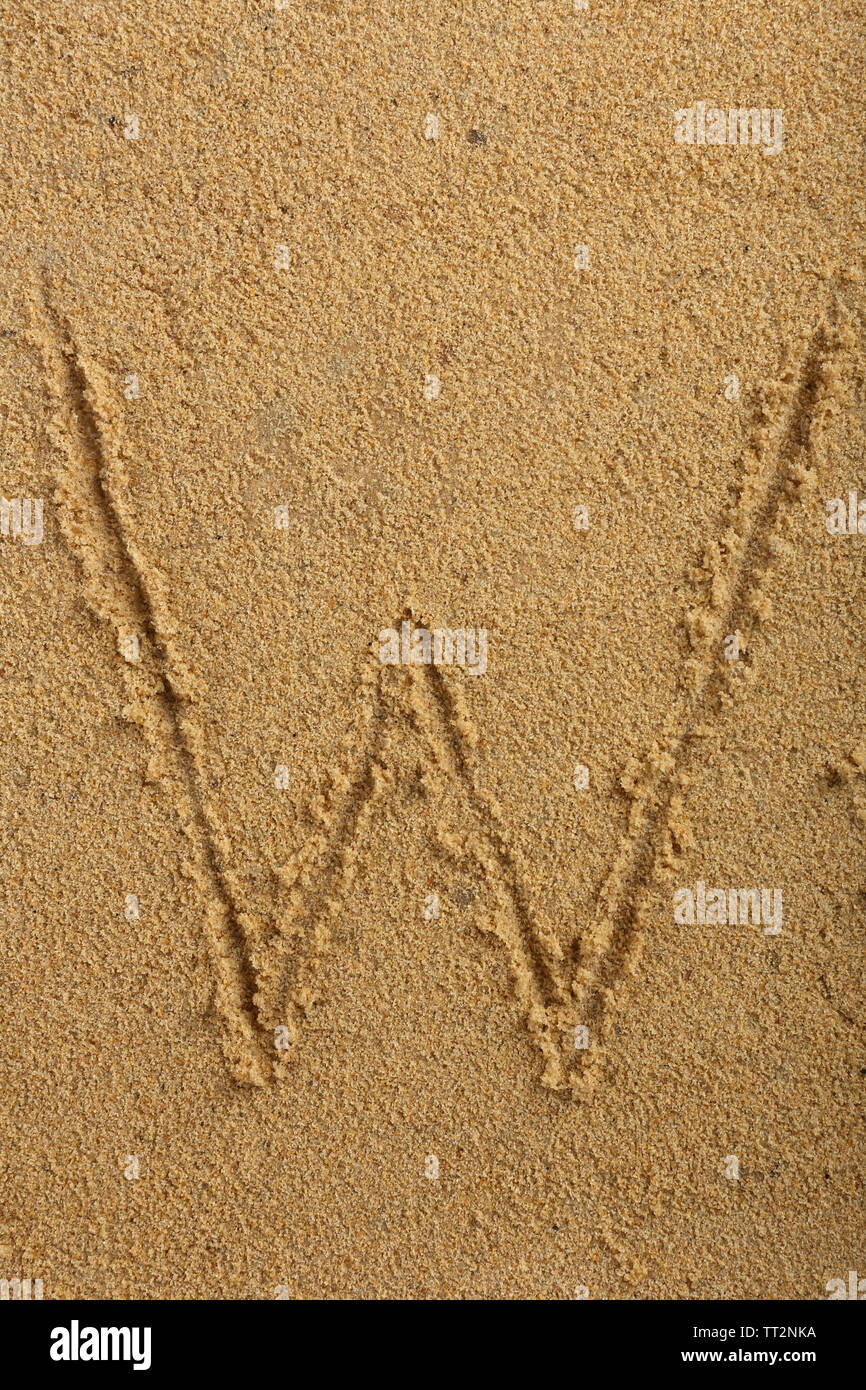 Alphabet letter written on wet beach sand Stock Photo - Alamy