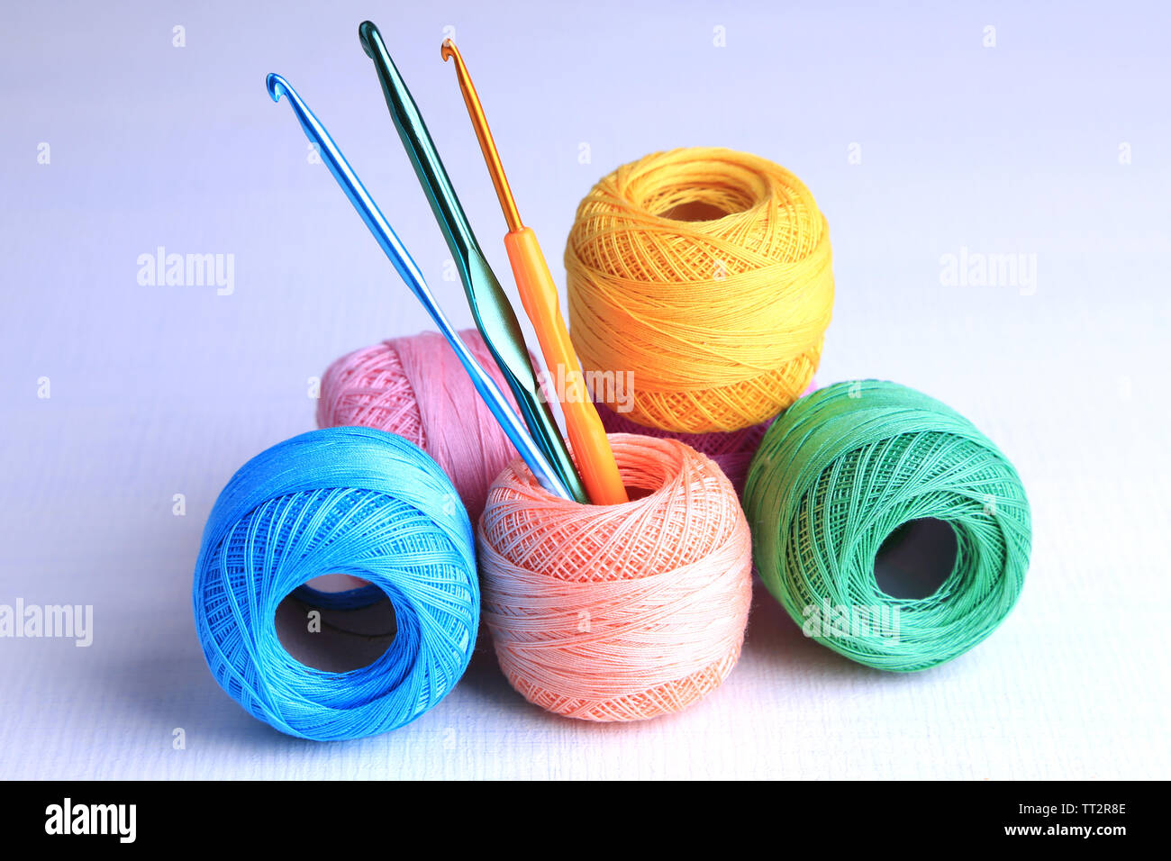Colorful clews and crochet hooks on light background Stock Photo - Alamy