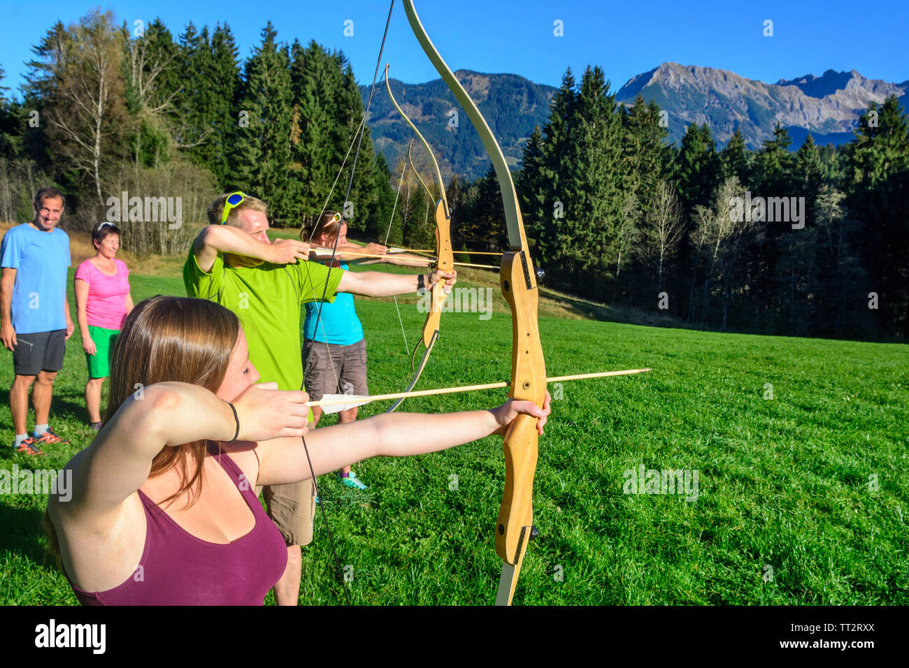 A group of adult people doing archery as an exercise during ...