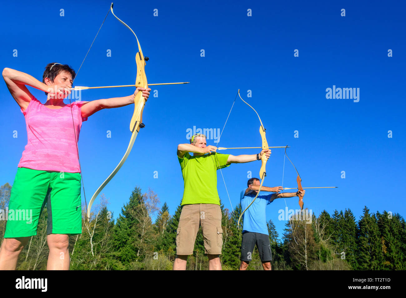 A group of adult people doing archery as an exercise during ...