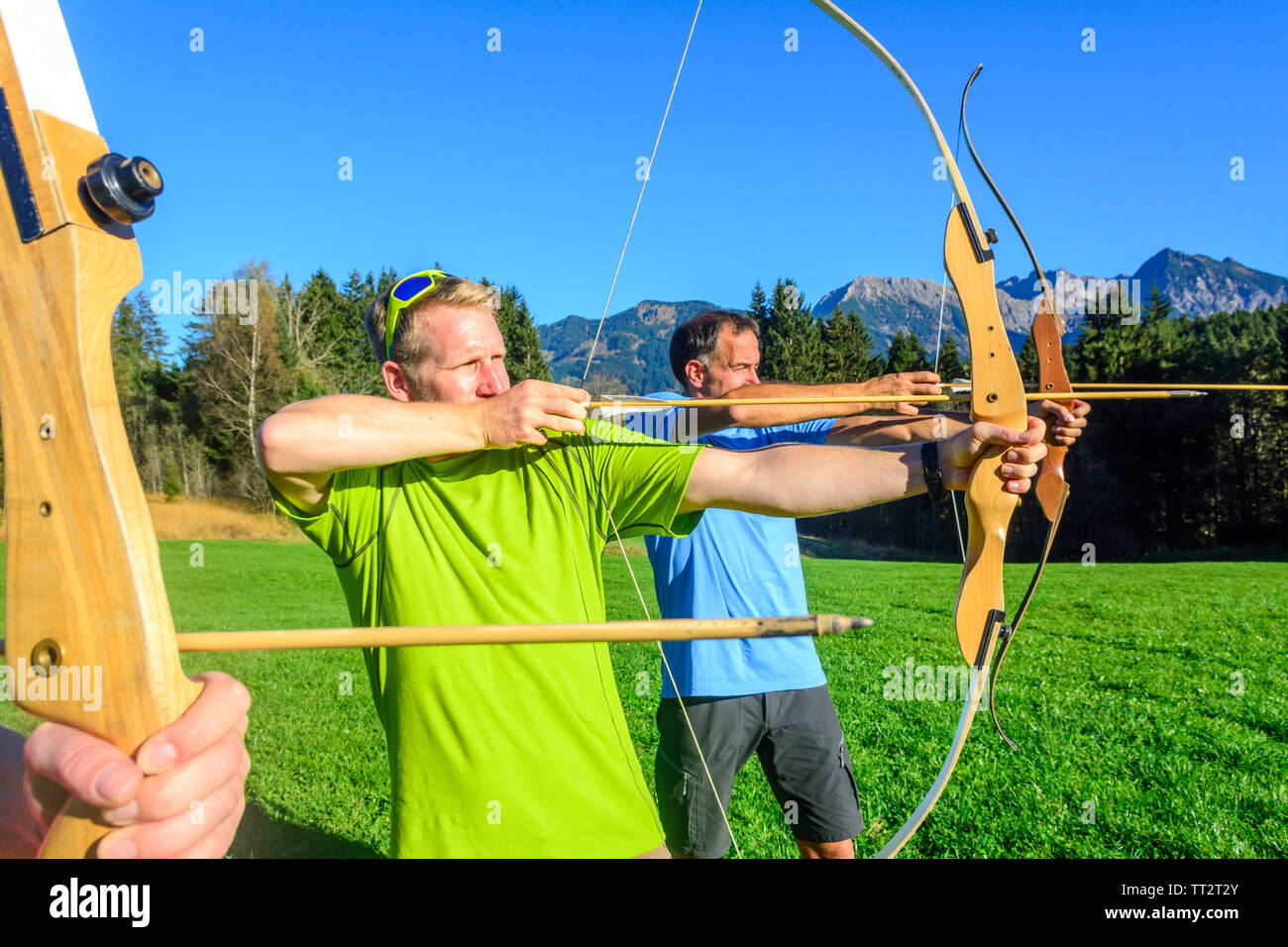 A group of adult people doing archery as an exercise during ...