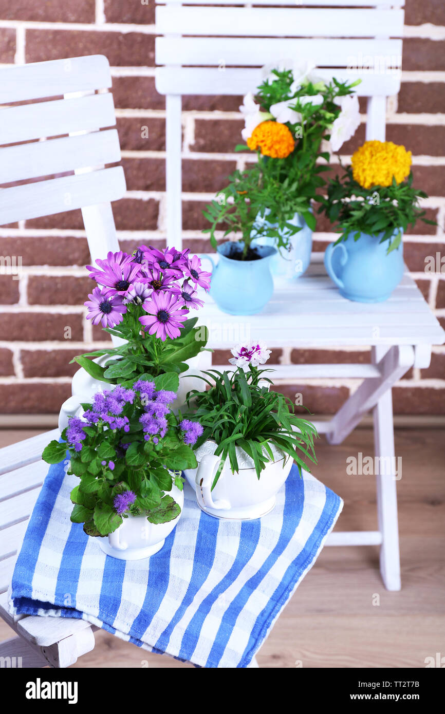 Flowers in decorative pots on table, on bricks background Stock Photo ...