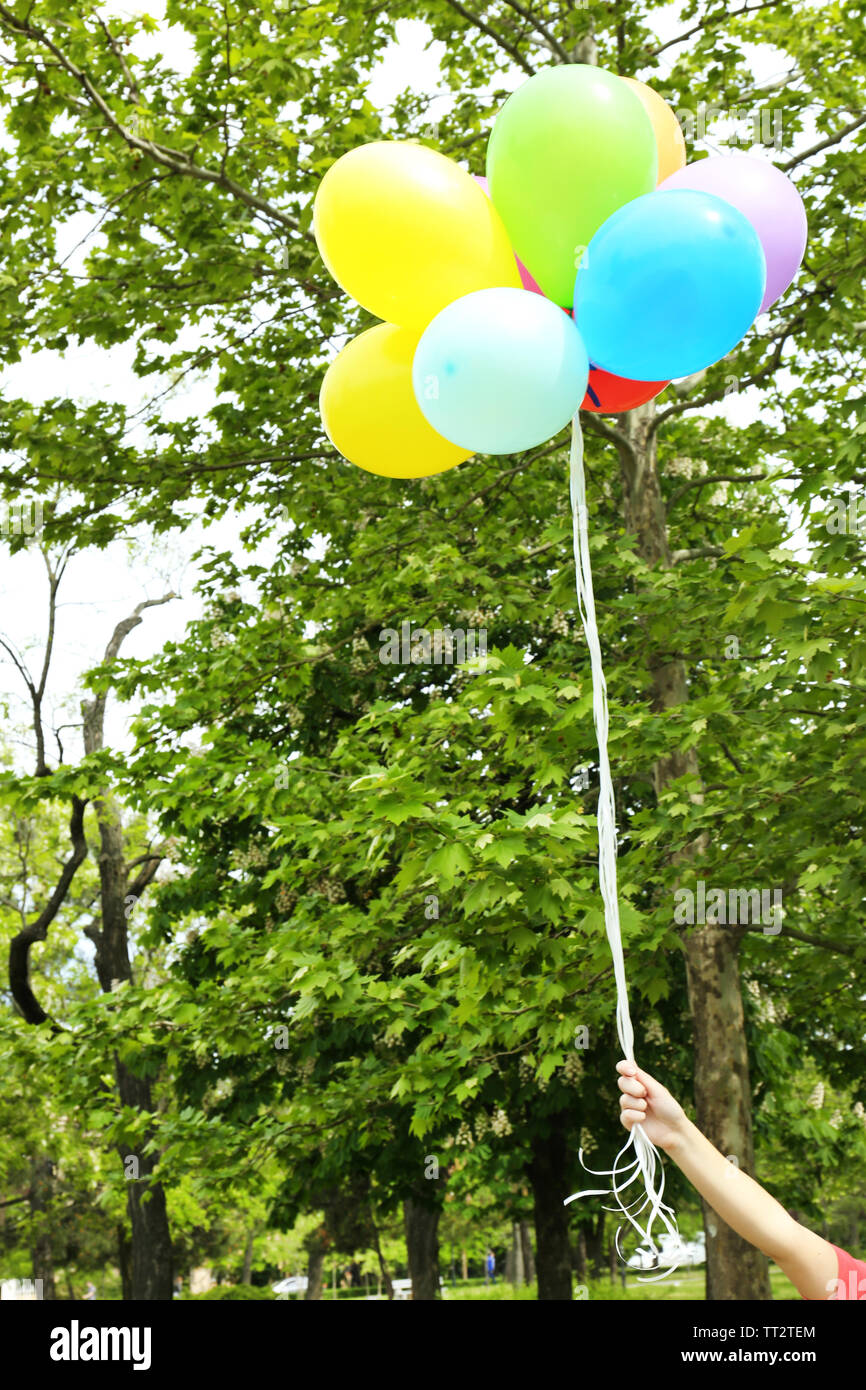 Balloons in hand, outdoors Stock Photo - Alamy