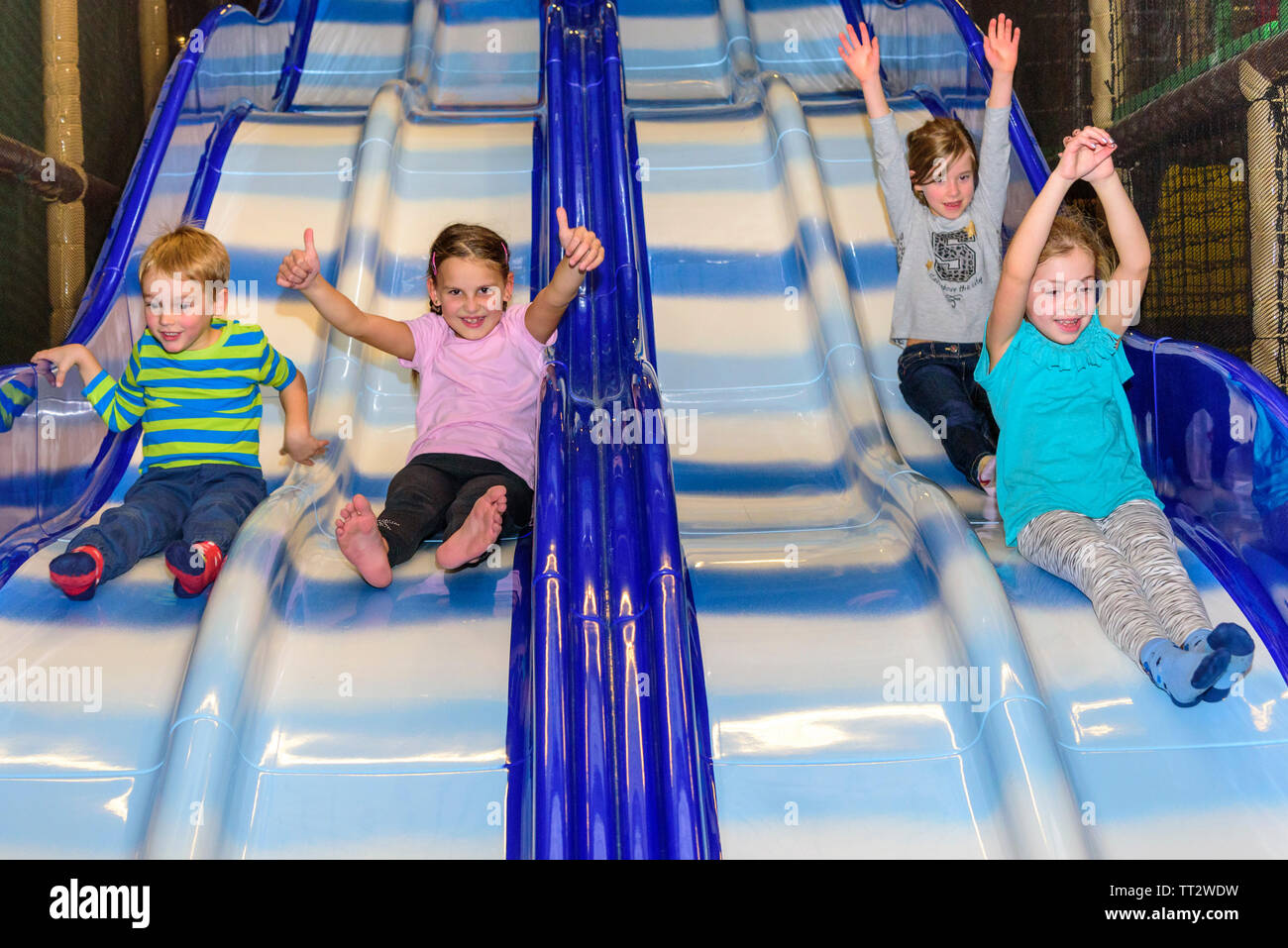 Sliding fun in indoor playground Stock Photo - Alamy