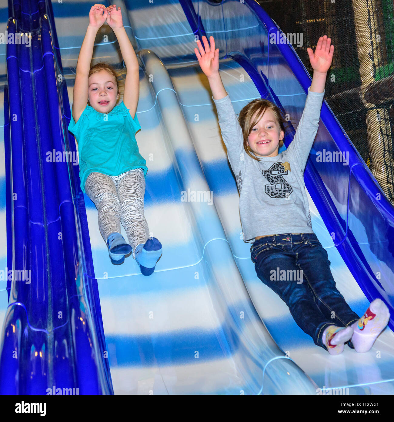 Sliding fun in indoor playground Stock Photo - Alamy