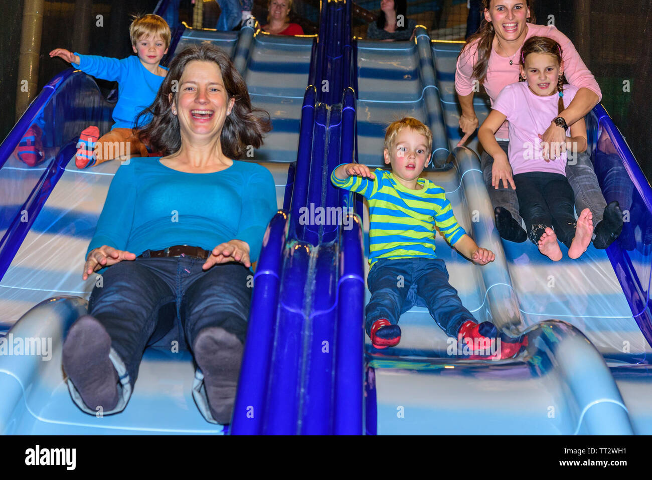 Sliding fun in indoor playground Stock Photo - Alamy