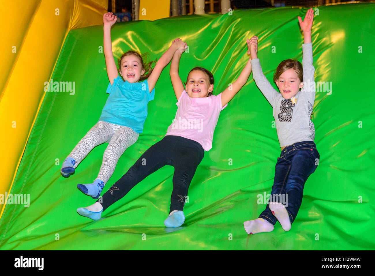 Sliding fun in indoor playground Stock Photo - Alamy