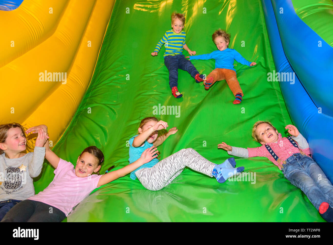 Sliding fun in indoor playground Stock Photo - Alamy
