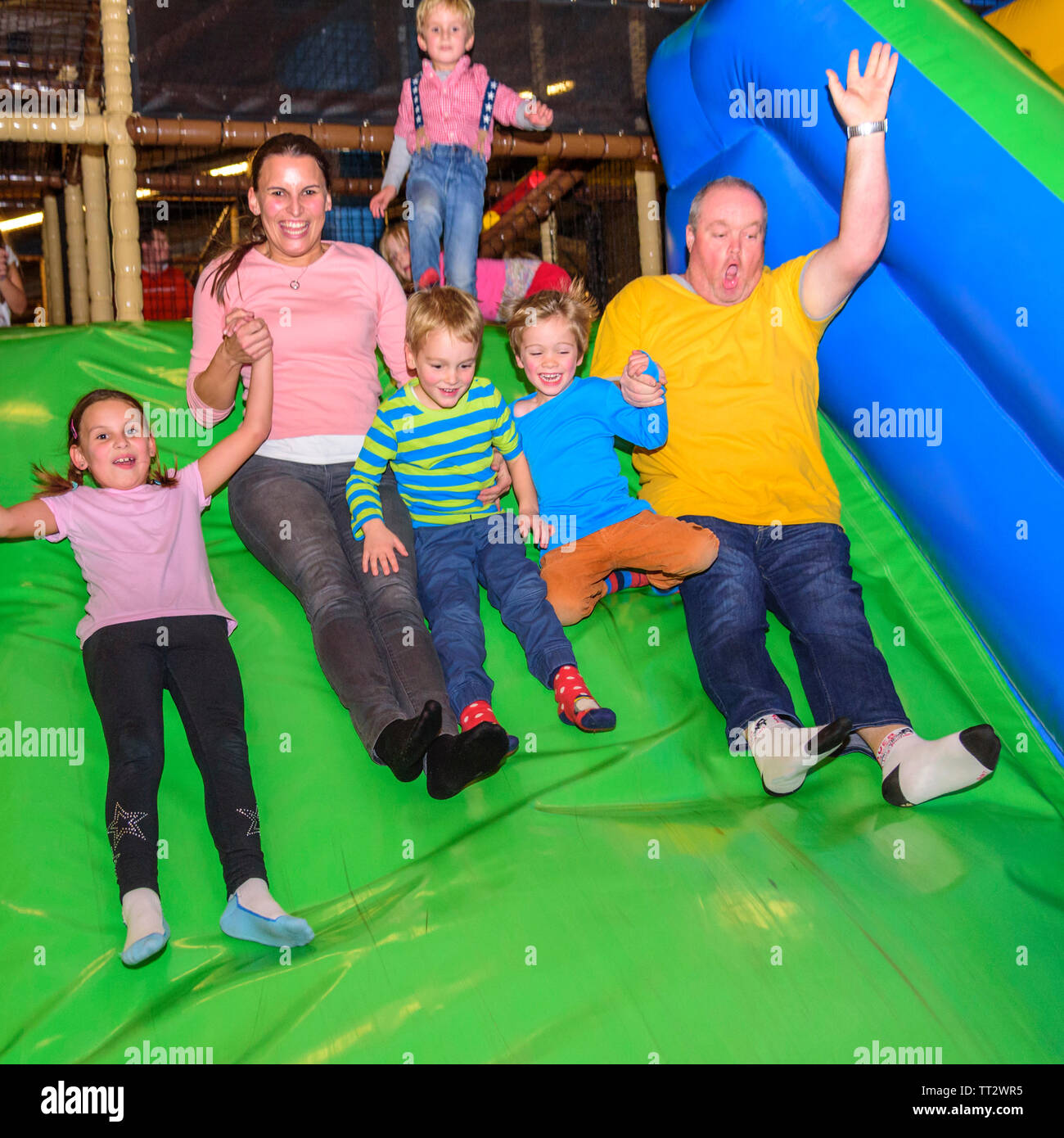 Sliding fun in indoor playground Stock Photo - Alamy