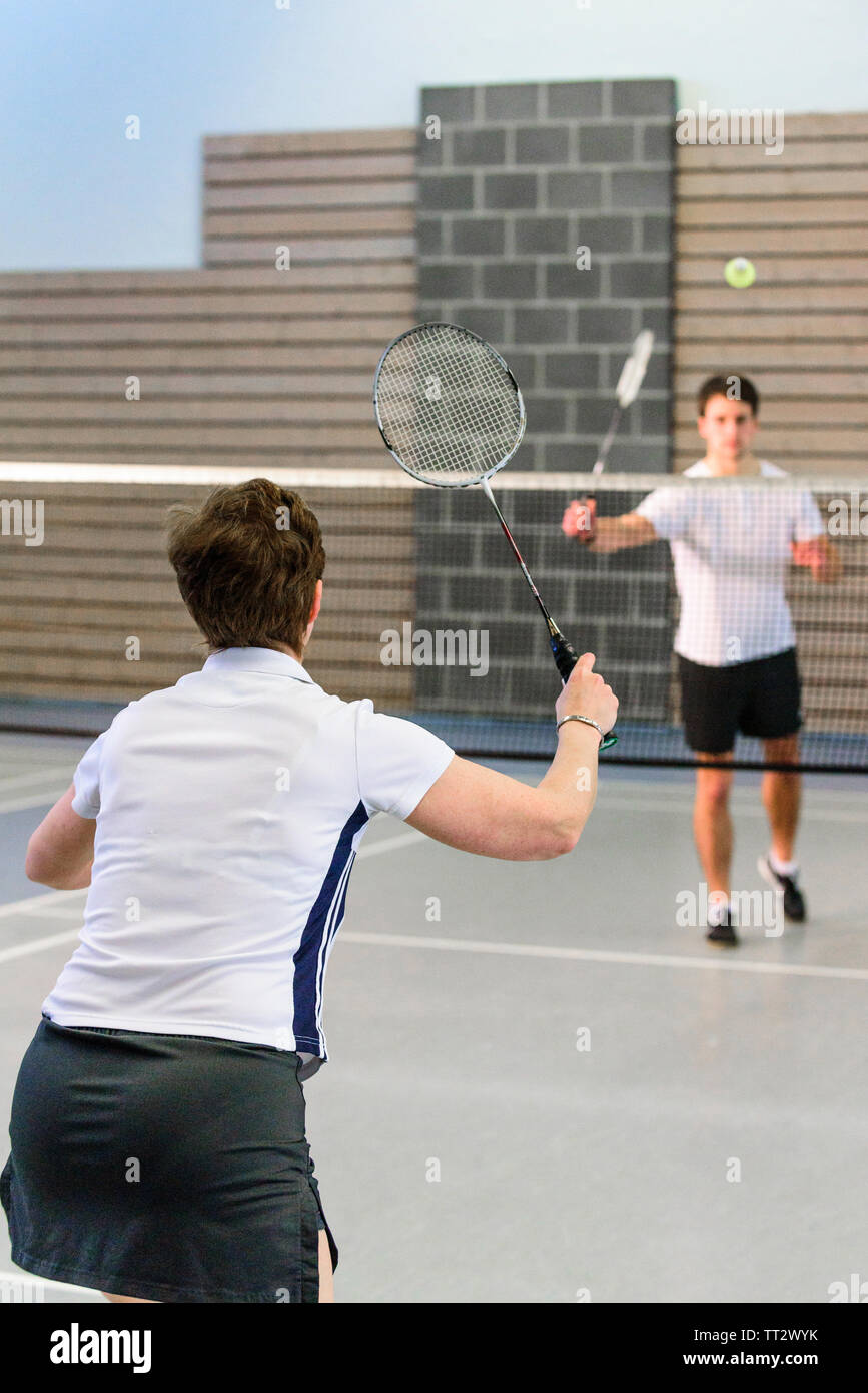 Badminton game scene in sports hall, a lot of effort and commitment ...
