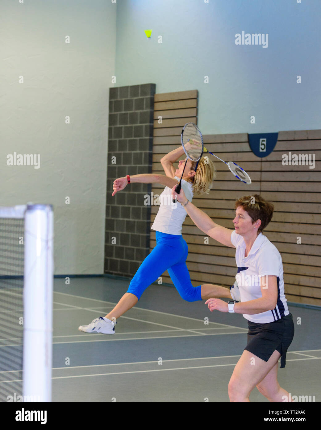 Badminton game scene in sports hall, a lot of effort and commitment ...