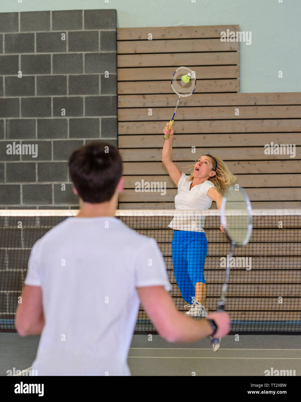 Badminton game scene in sports hall, a lot of effort and commitment ...