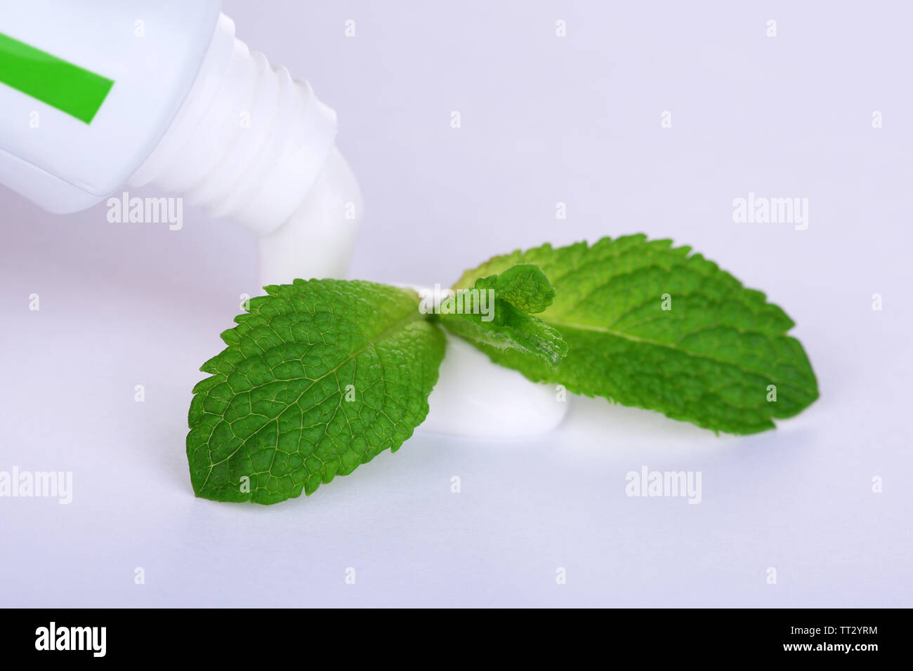 Toothpaste squeezed from tube, mint leaves, close-up, isolated on white ...